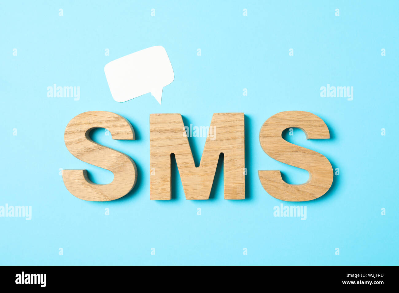 Word SMS lined with wooden letters on color background Stock Photo - Alamy
