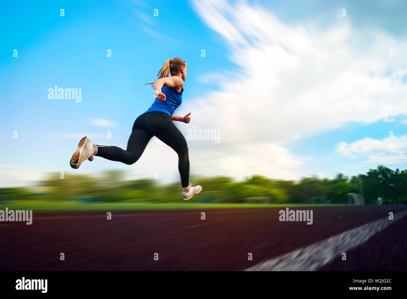 The young girl running in stadium, blur in moving. An athlete runs ...