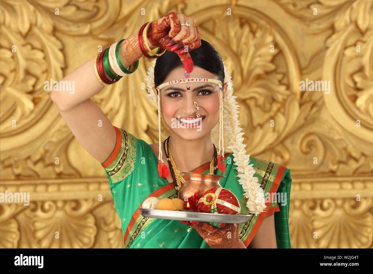 Portrait of an Indian bride applying tika Stock Photo - Alamy
