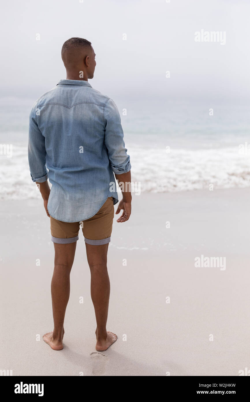 Thoughtful man looking at sea on the beach Stock Photo - Alamy