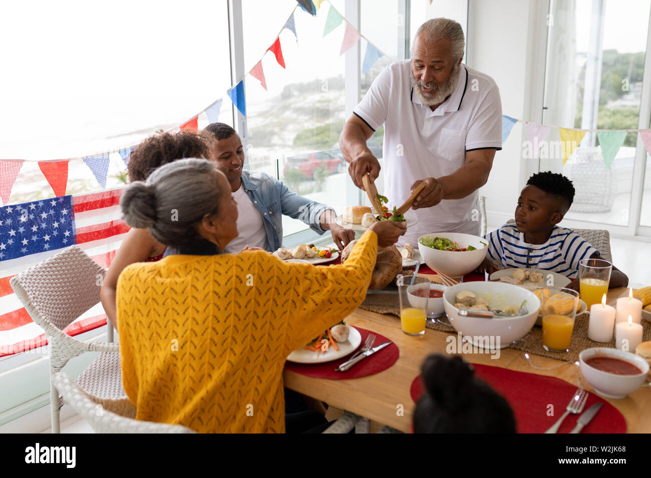 Multi-generation family having meal on a dining table Stock Photo - Alamy