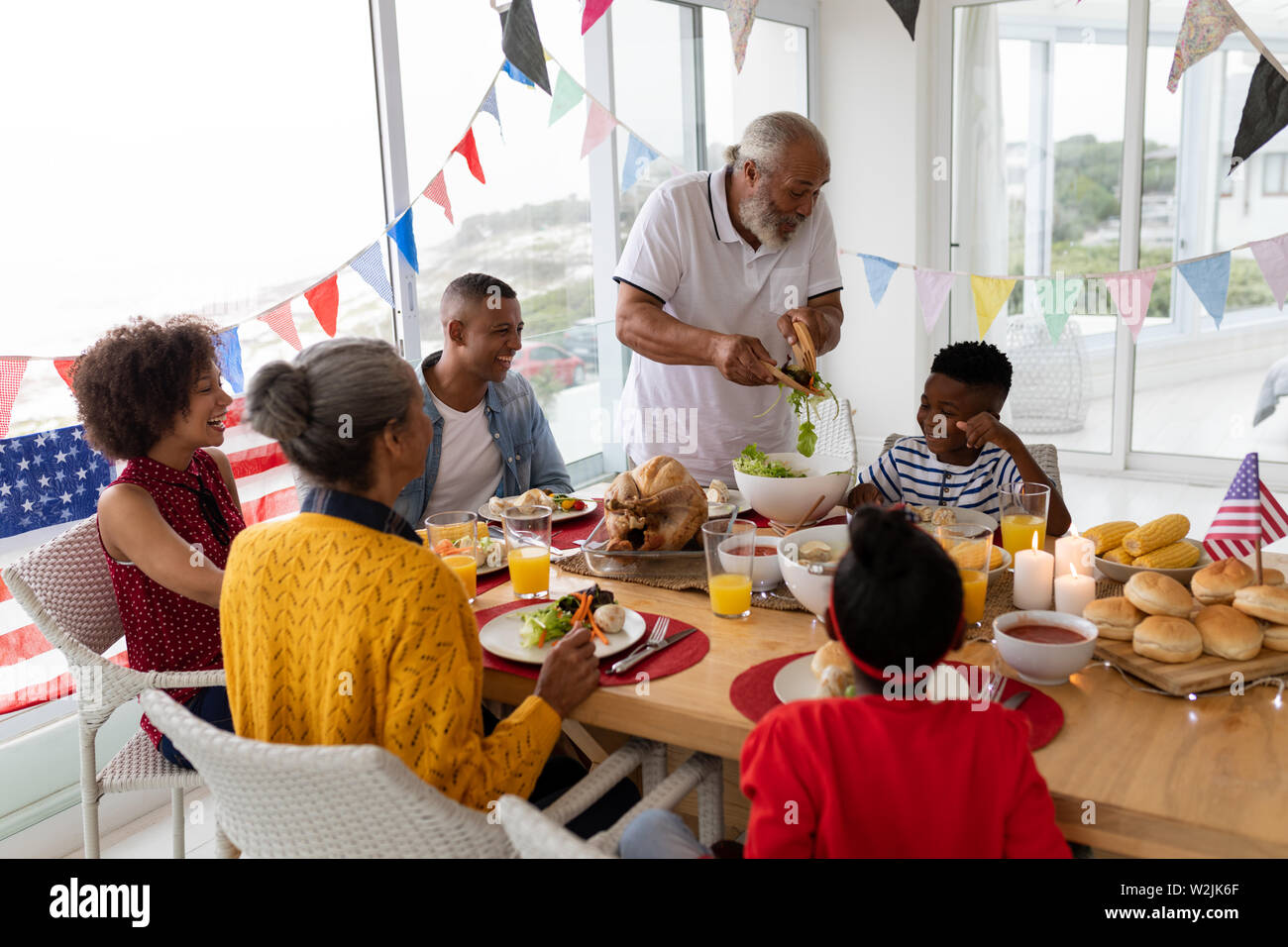 Multi-generation family having meal on a dining table Stock Photo - Alamy