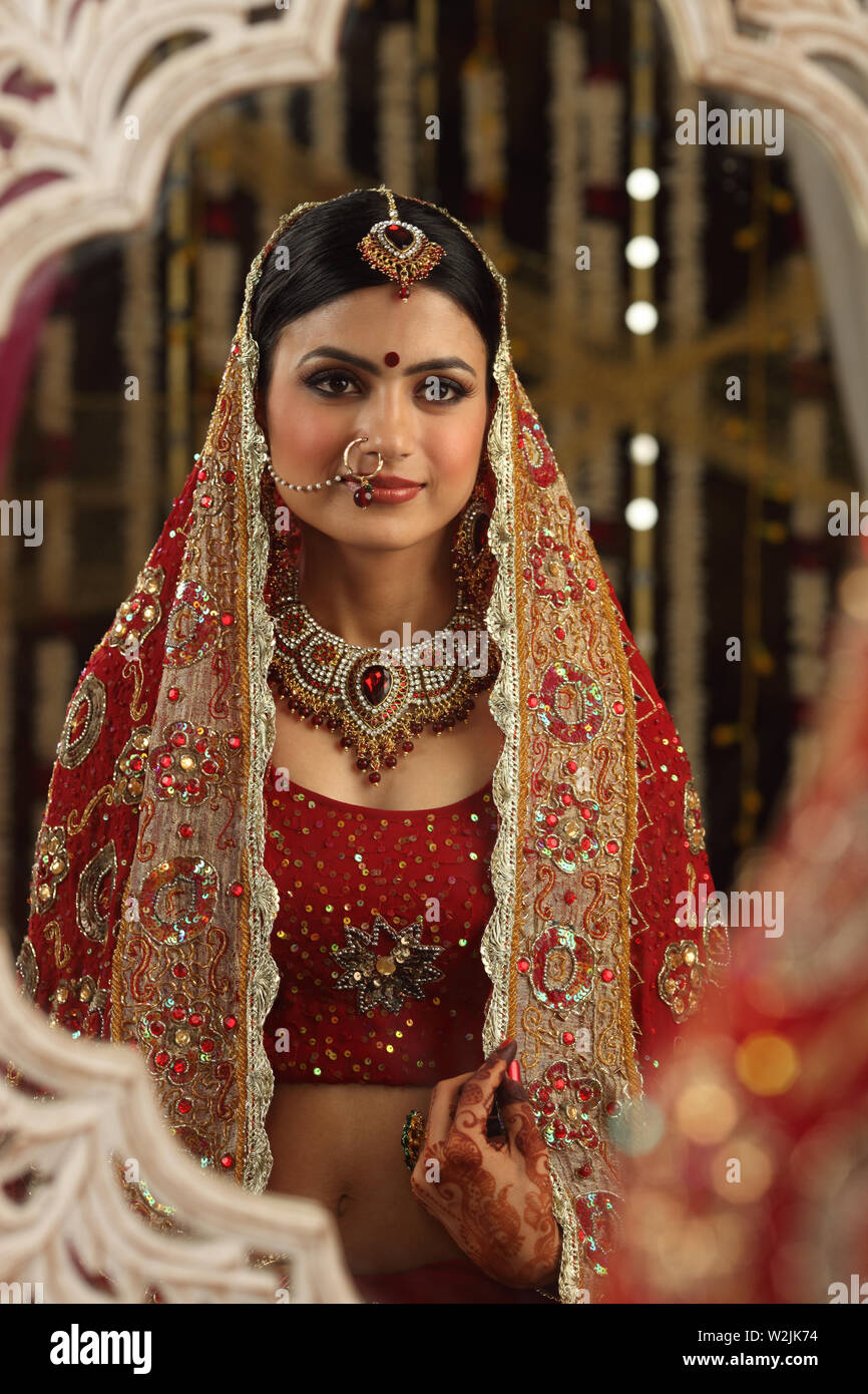 Indian bride admiring herself in mirror Stock Photo - Alamy
