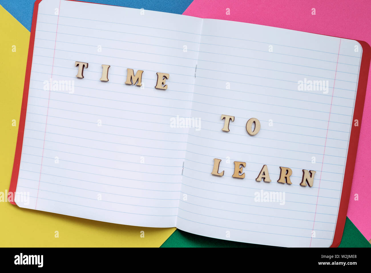 Time to learn, text in an open notebook, colored paper sheets. Concept ...