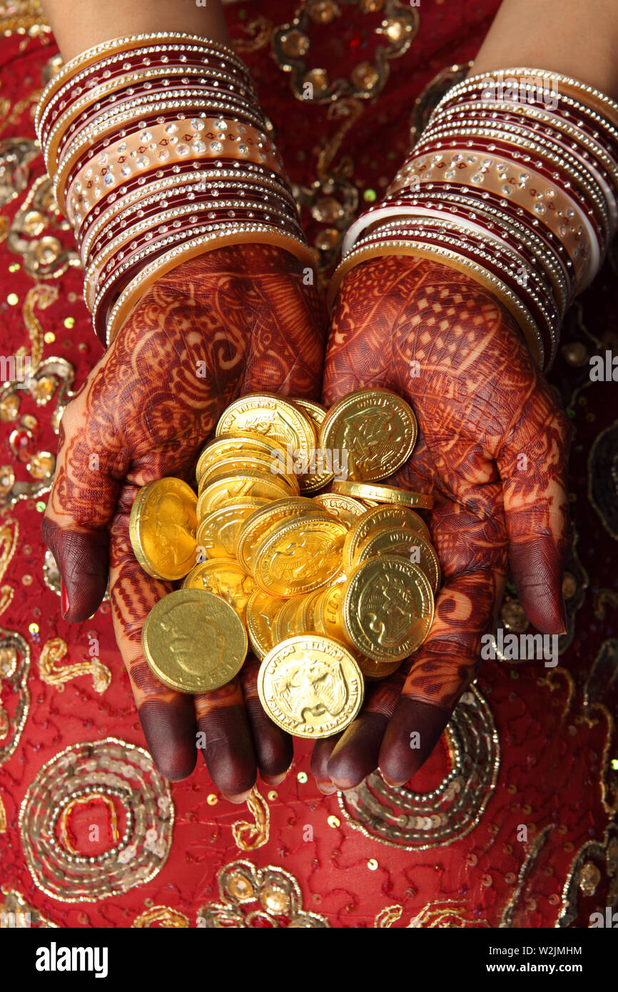 Indian bride holding gold coins Stock Photo - Alamy