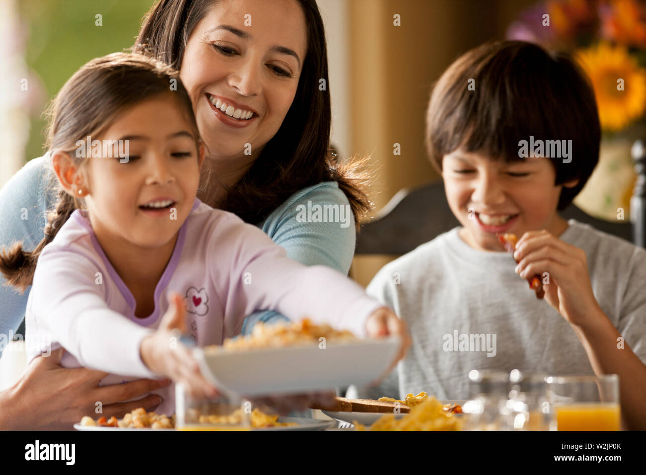 Happy family having fun eating at a dining table Stock Photo - Alamy