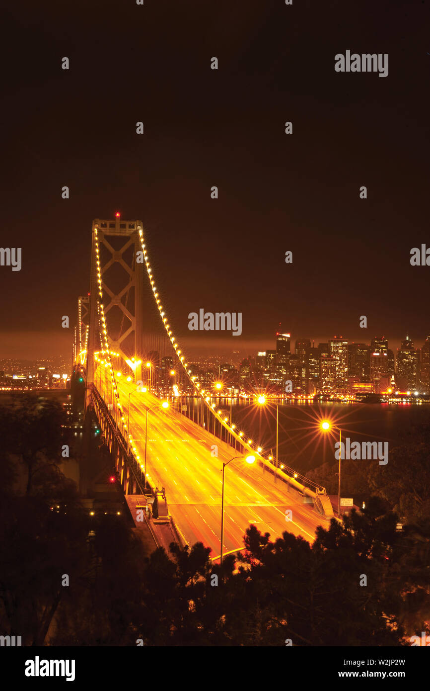 Bridge and city skyline at night Stock Photo - Alamy