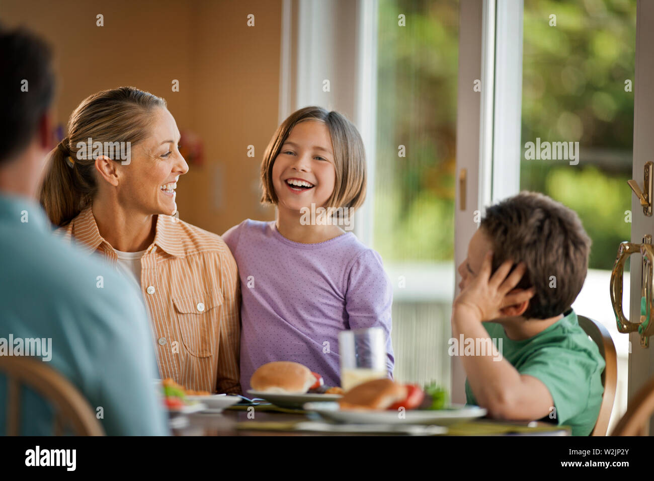 Happy family having fun eating at a dining table Stock Photo - Alamy