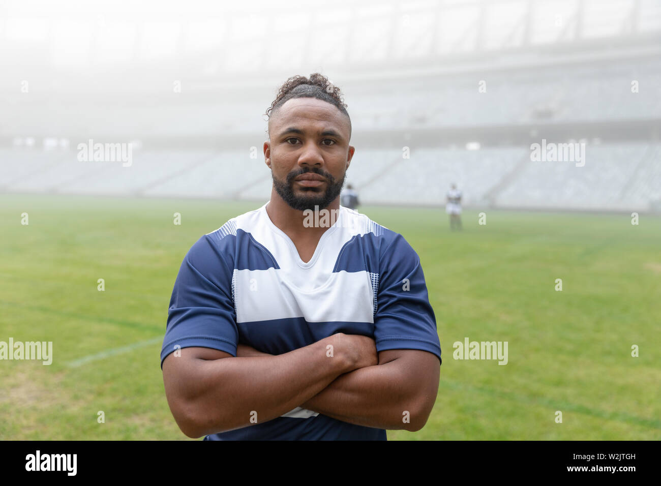 African american rugby player standing with arms crossed in the stadium ...