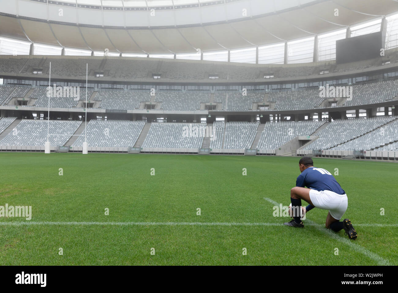 Male rugby player placing rugby ball on a stand in stadium Stock Photo ...
