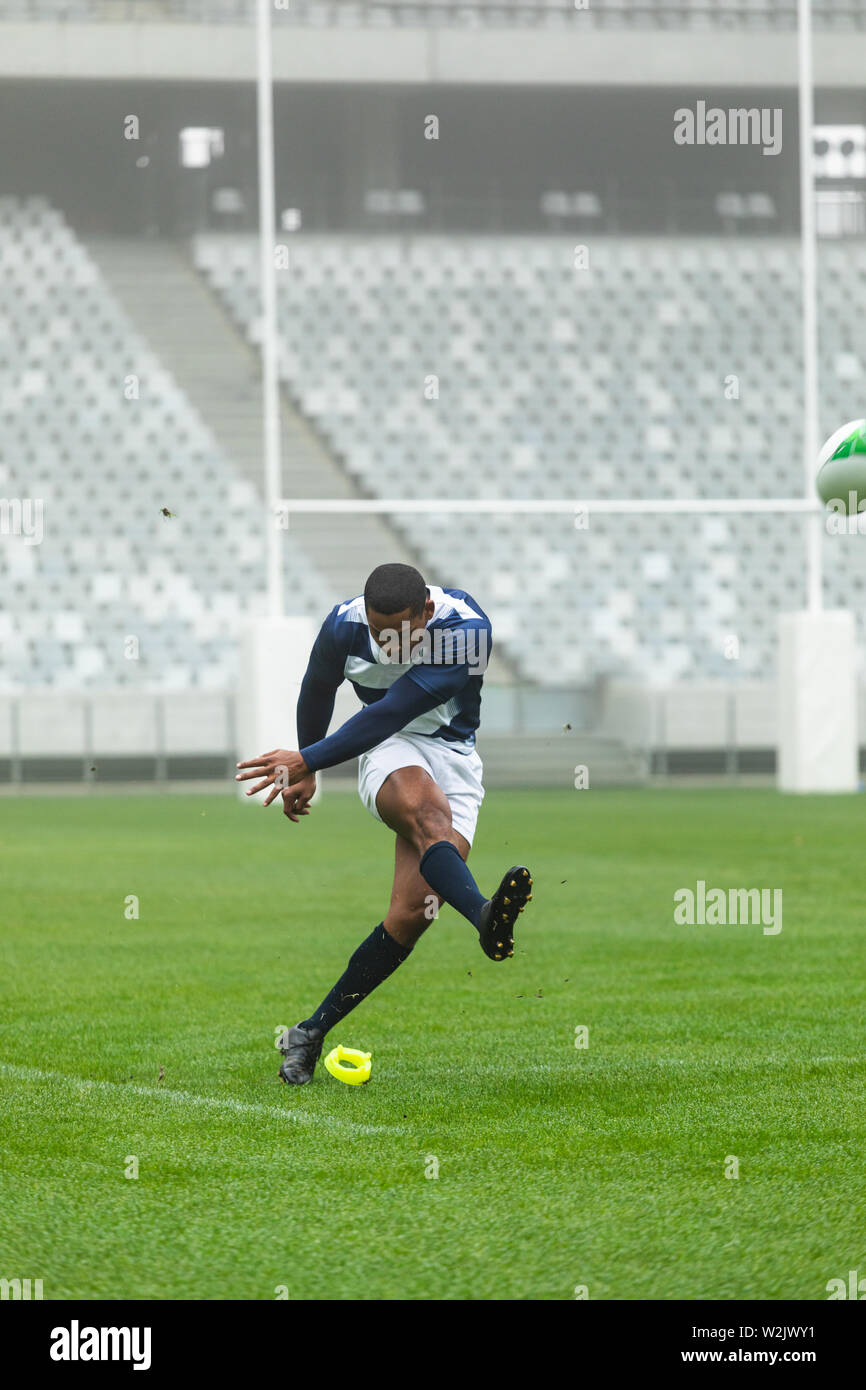 African American male rugby player kicking rugby ball in stadium Stock ...