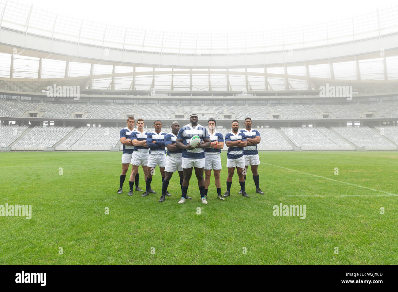Group of diverse male rugby players standing together with rugby ball ...