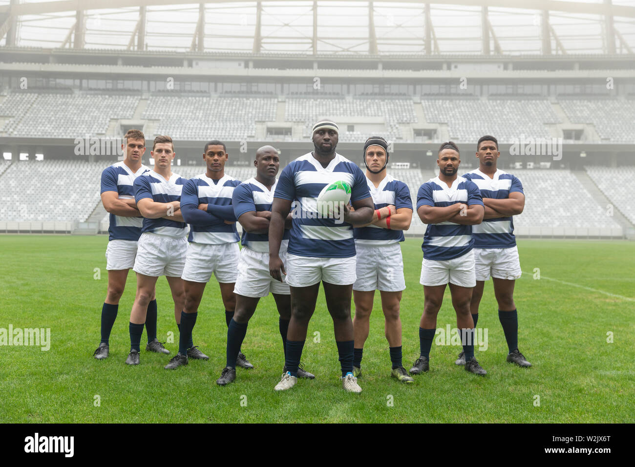 Group of diverse male rugby players standing together with rugby ball ...