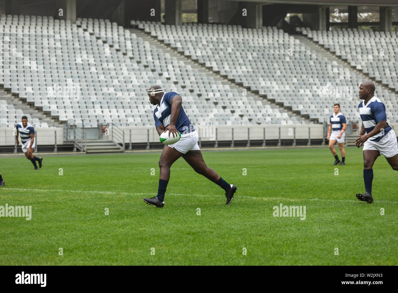 Group of diverse male rugby players playing rugby in stadium Stock ...