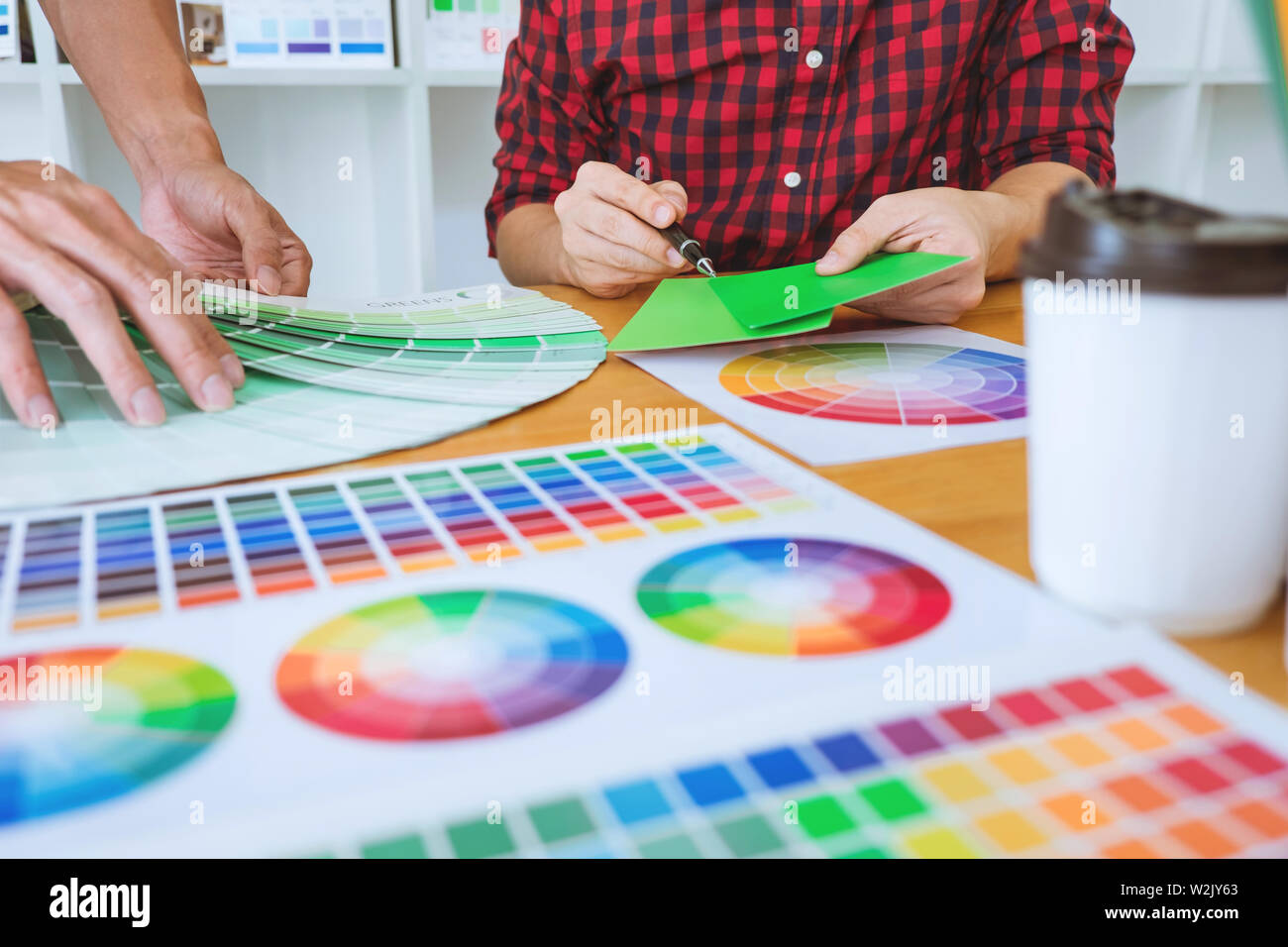 Teamwork of young creative designers working on project together and ...