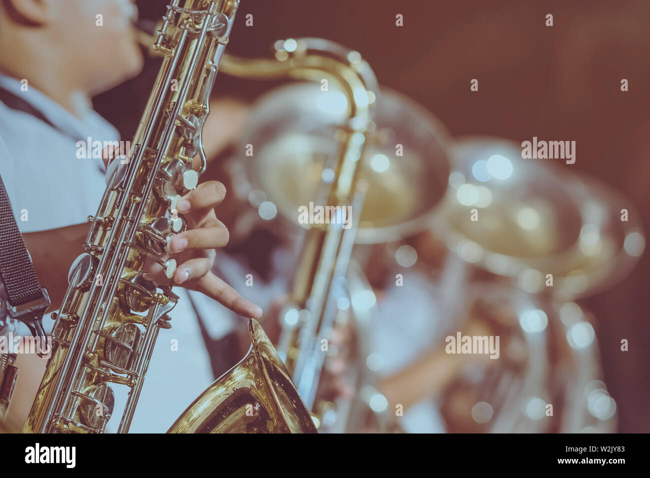 Male student with friends blow the saxophone with the band for ...