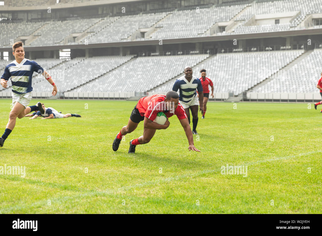 Group of diverse male rugby players playing rugby in stadium Stock ...