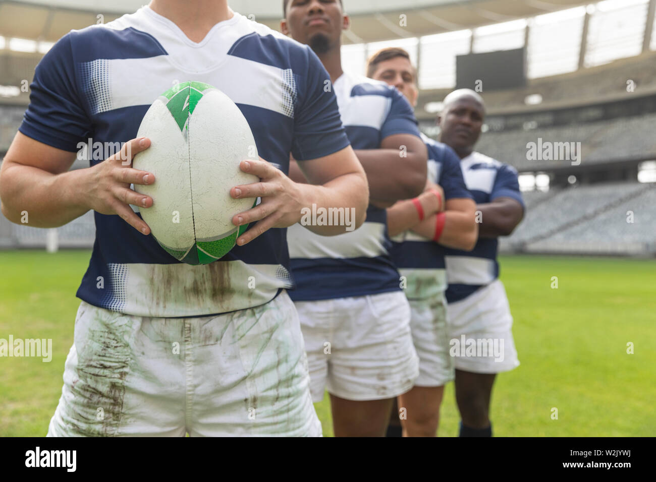 Male rugby players standing together with rugby ball in stadium Stock ...