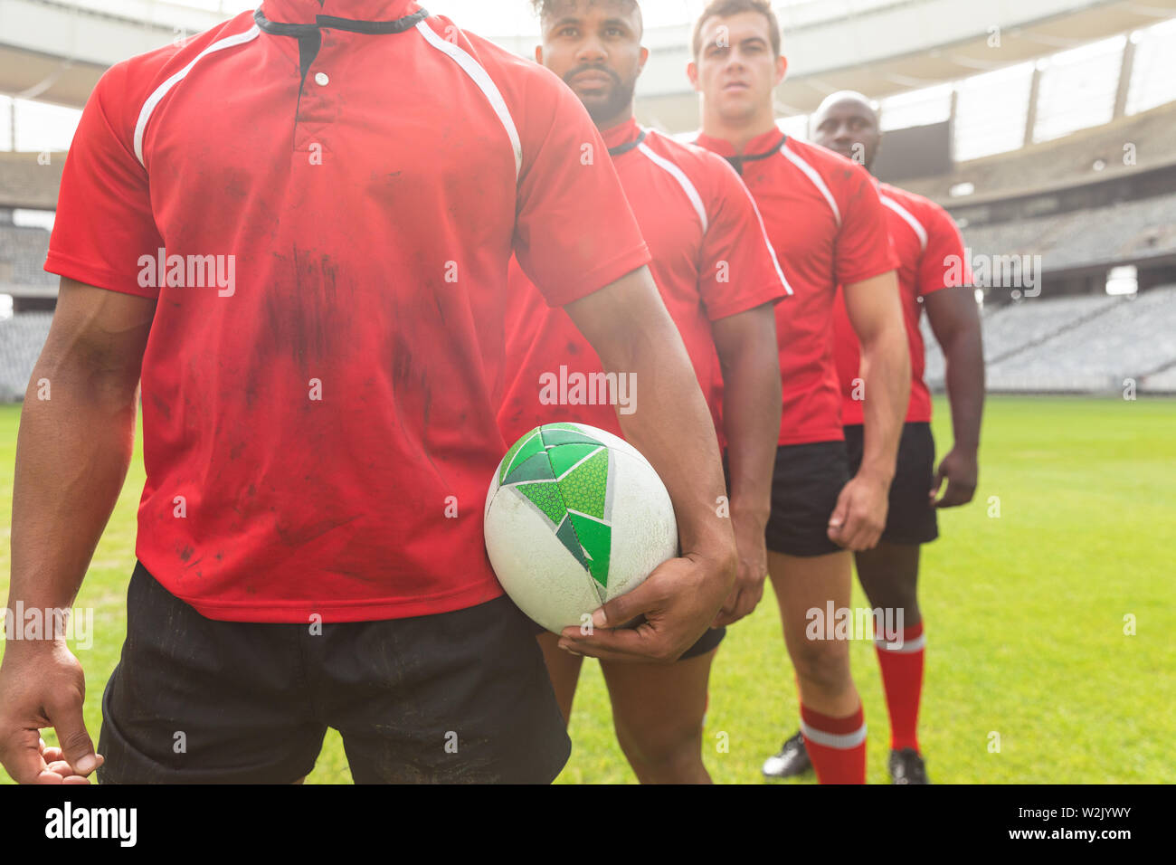 Male rugby players standing together with rugby ball in stadium Stock ...