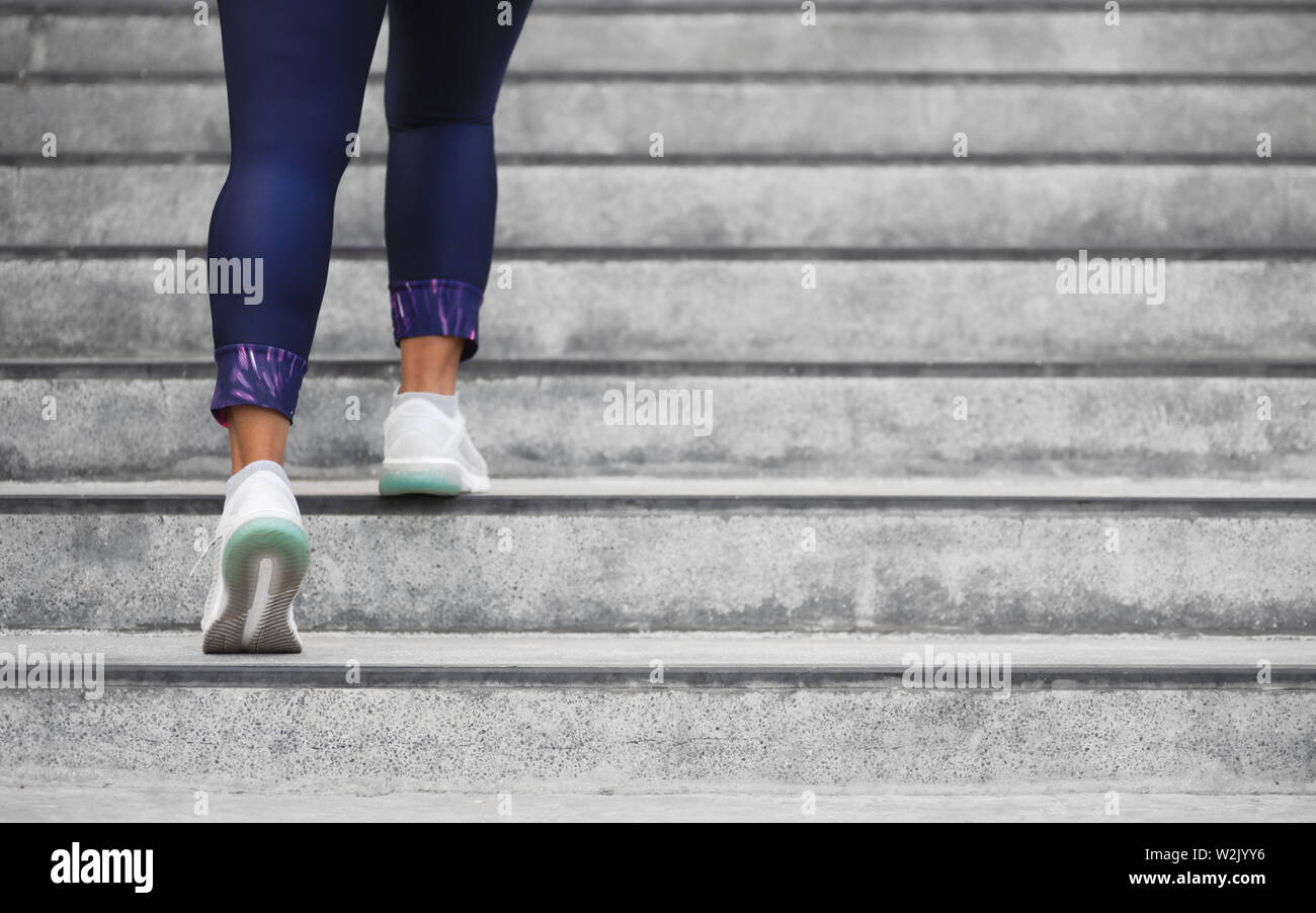 Female runner athlete doing a stairs climbing. Running woman doing run ...