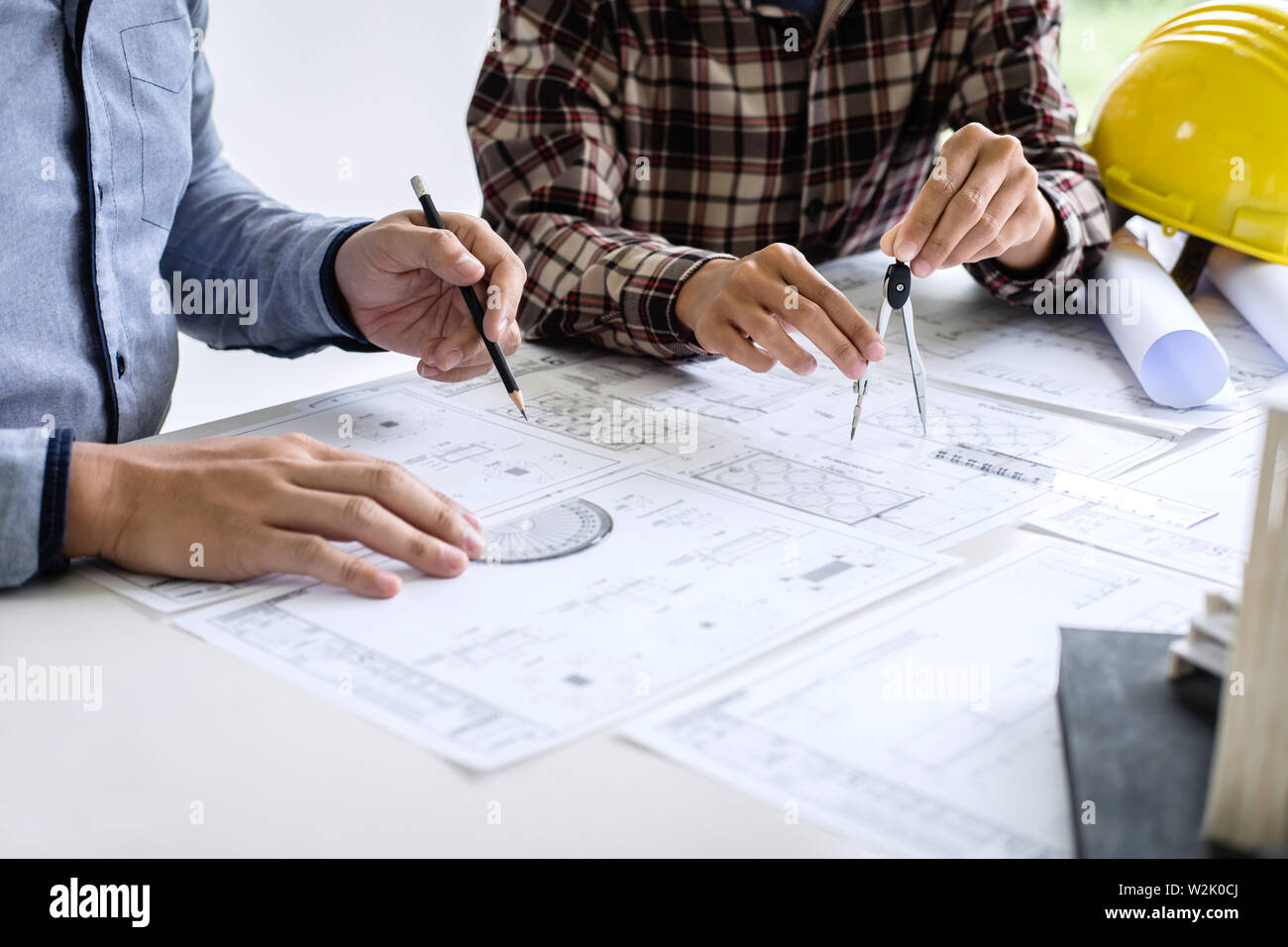 Construction engineering or architect discuss a blueprint while ...