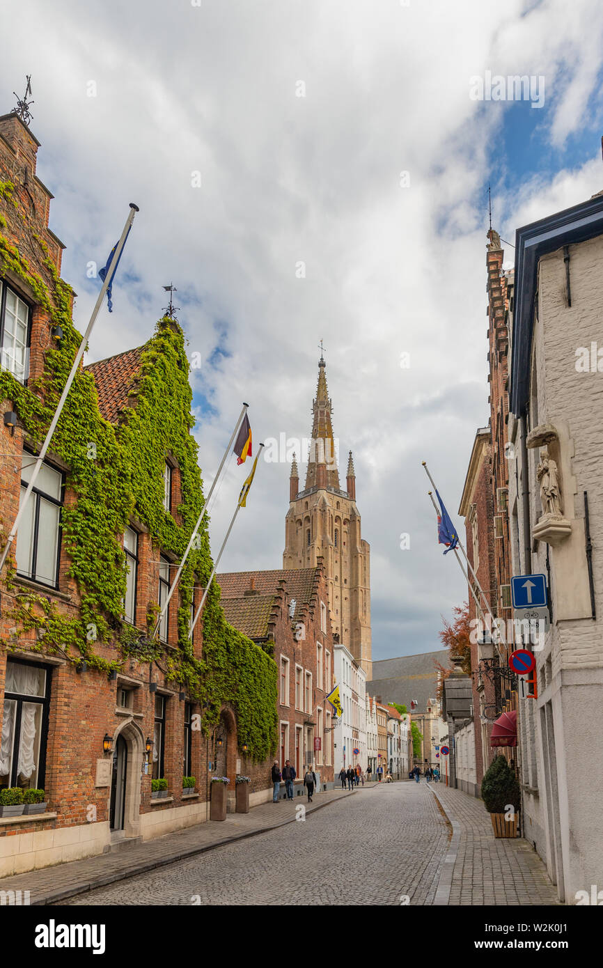 View of street with traditional red brick buildings and Church of Our ...