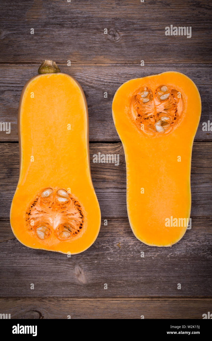 Sliced butternut squash over old wood background with intentional ...