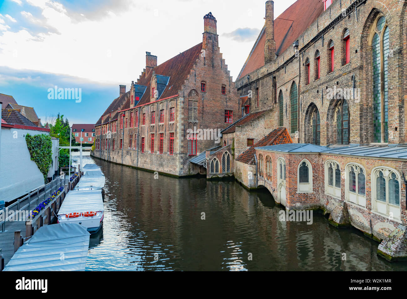View of Dijver canal with canal boats, trees and traditional buildings ...