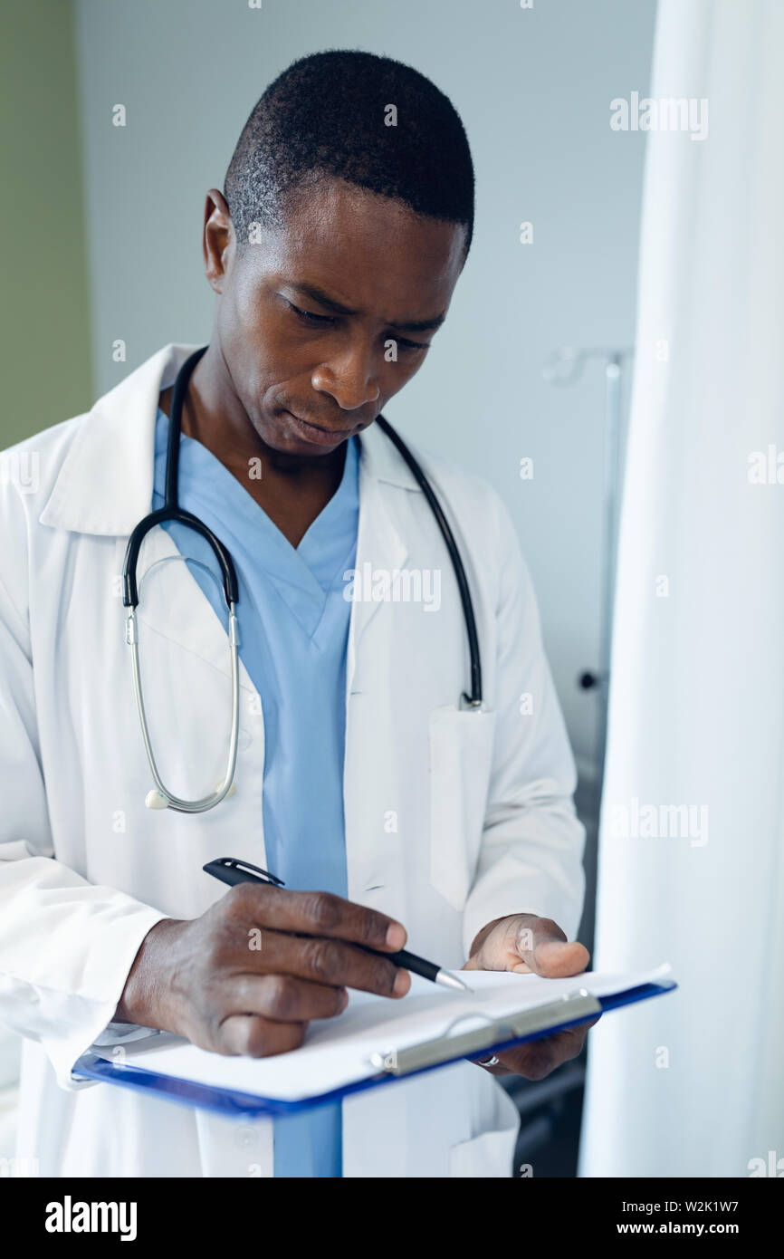 Male doctor checking medical report in the ward Stock Photo - Alamy