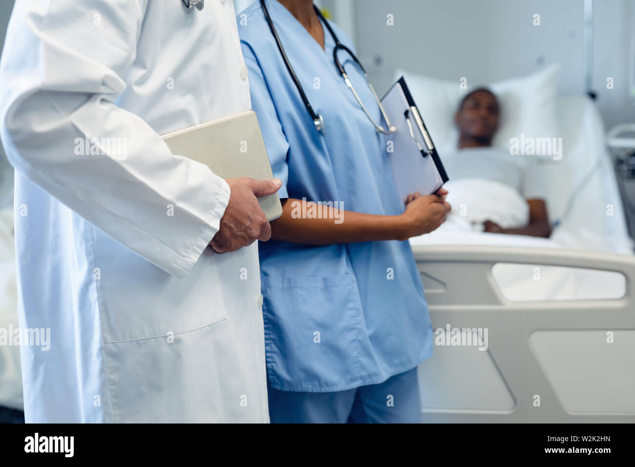 Male and female doctors holding digital tablet and clipboard in the ...