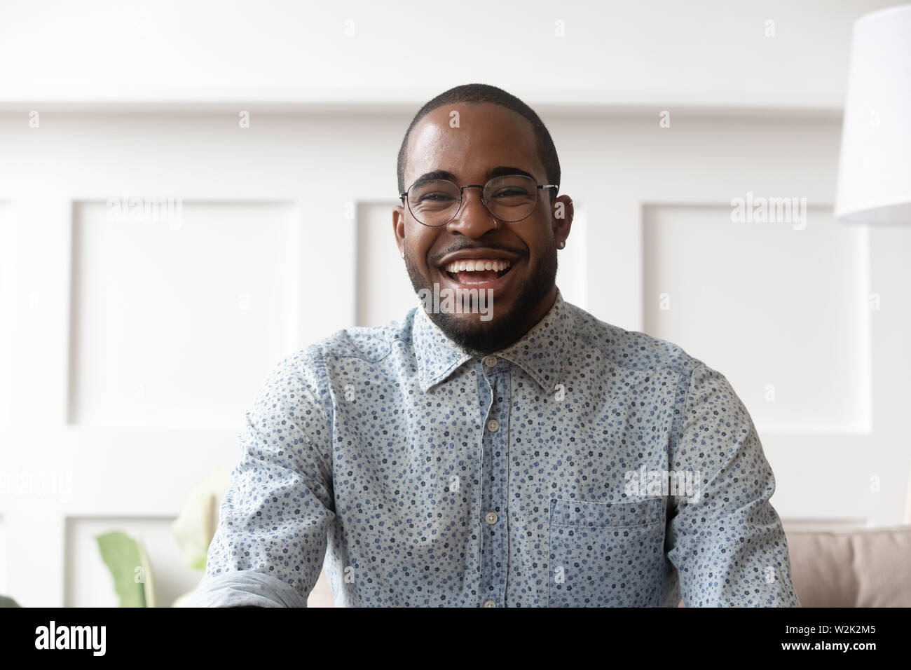 Happy black man video calling looking at camera at home Stock Photo - Alamy