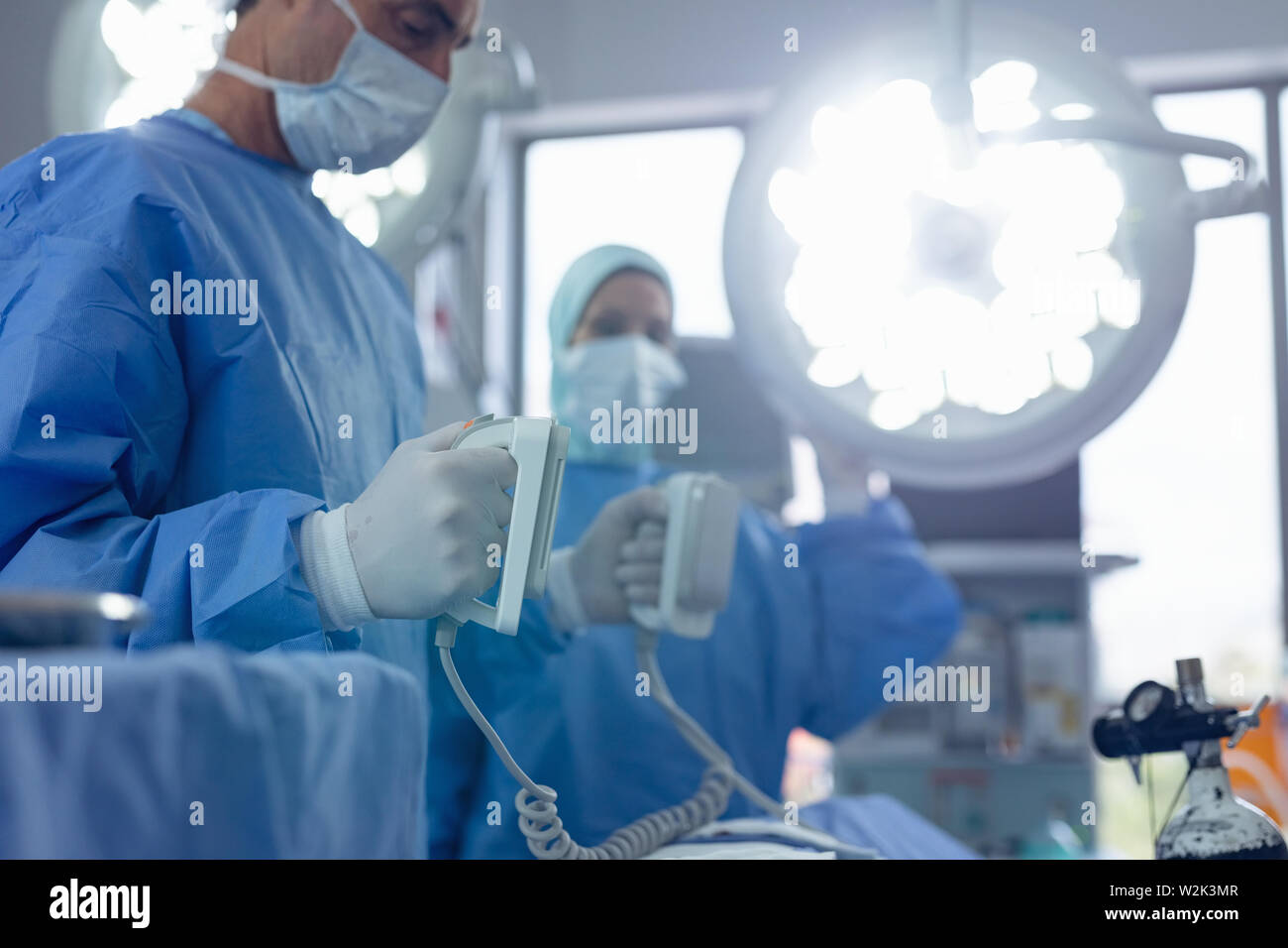 Male surgeon holding defibrillator in operation room at hospital Stock ...