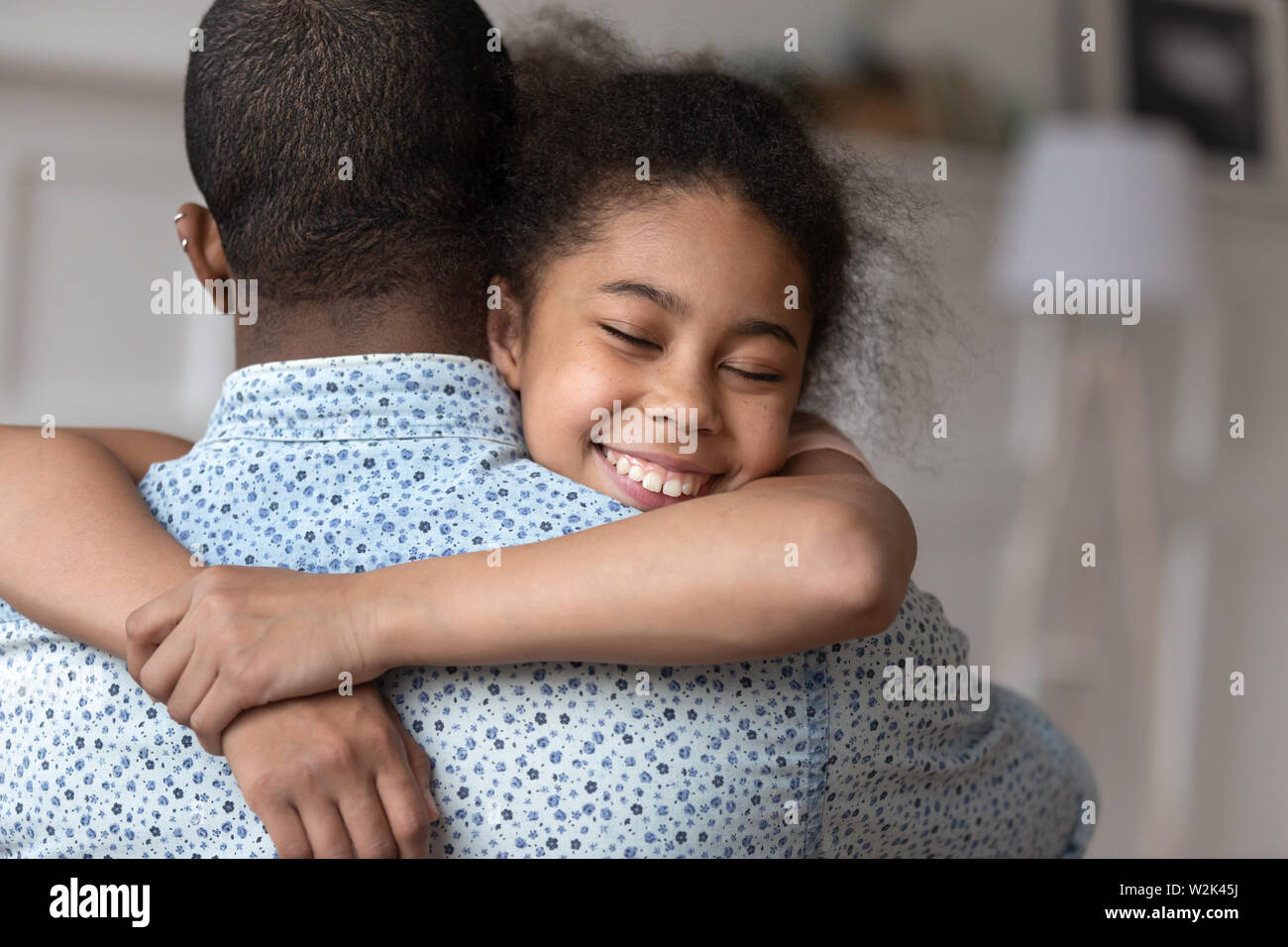 Smiling cute african american child daughter hugging dad feeling love ...