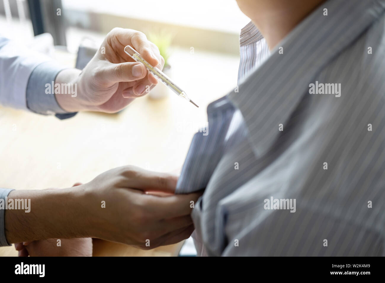 Doctor consulting using thermometer with patient examining for patient ...