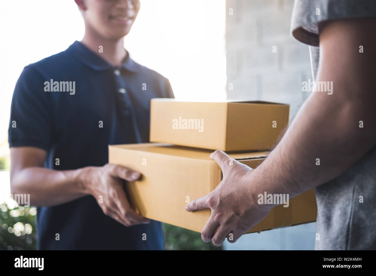 Delivery mail man giving parcel box to recipient, Young owner accepting ...