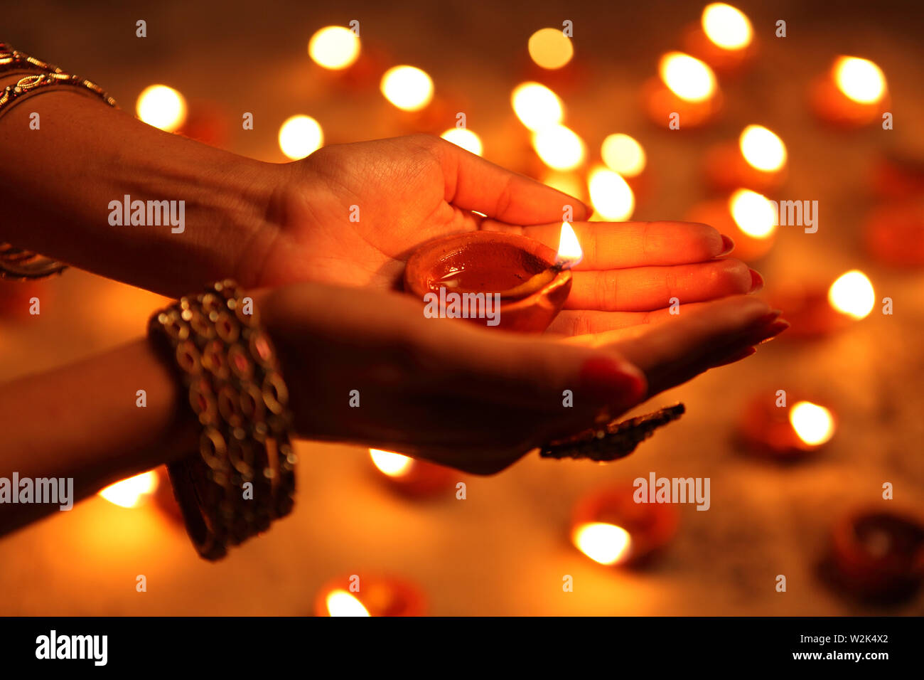 Traditional indian woman lighting diya hi-res stock photography and ...