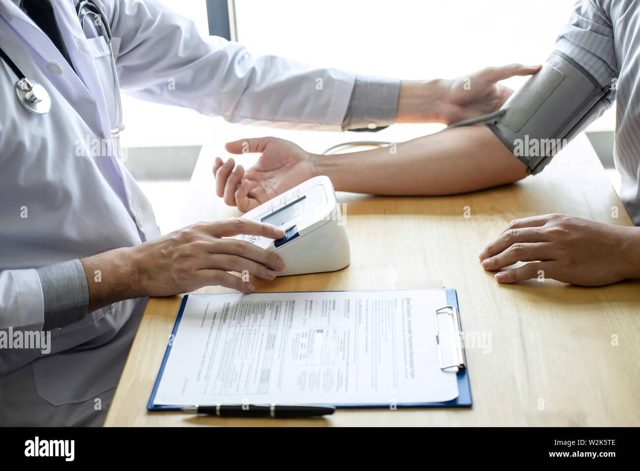 Doctor using a measuring blood pressure checking patient with examining ...
