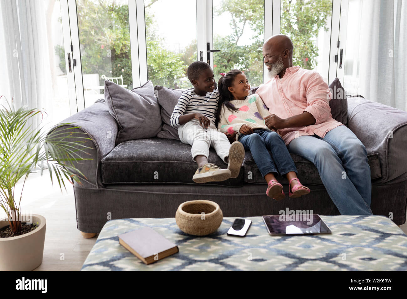 Multi-generation family having fun together on a sofa in living room ...