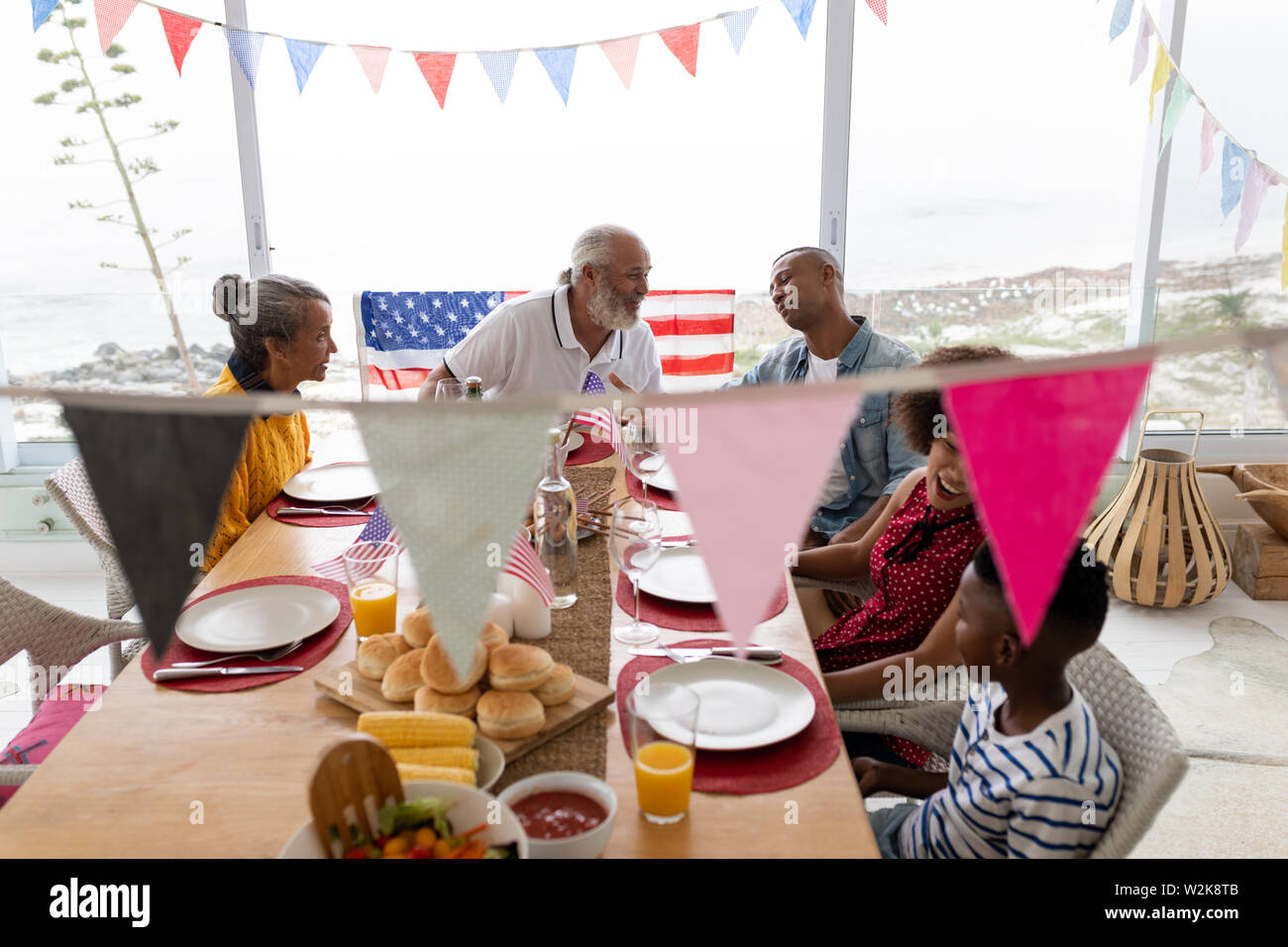 Multi-generation family sitting together for having meal on a dining ...