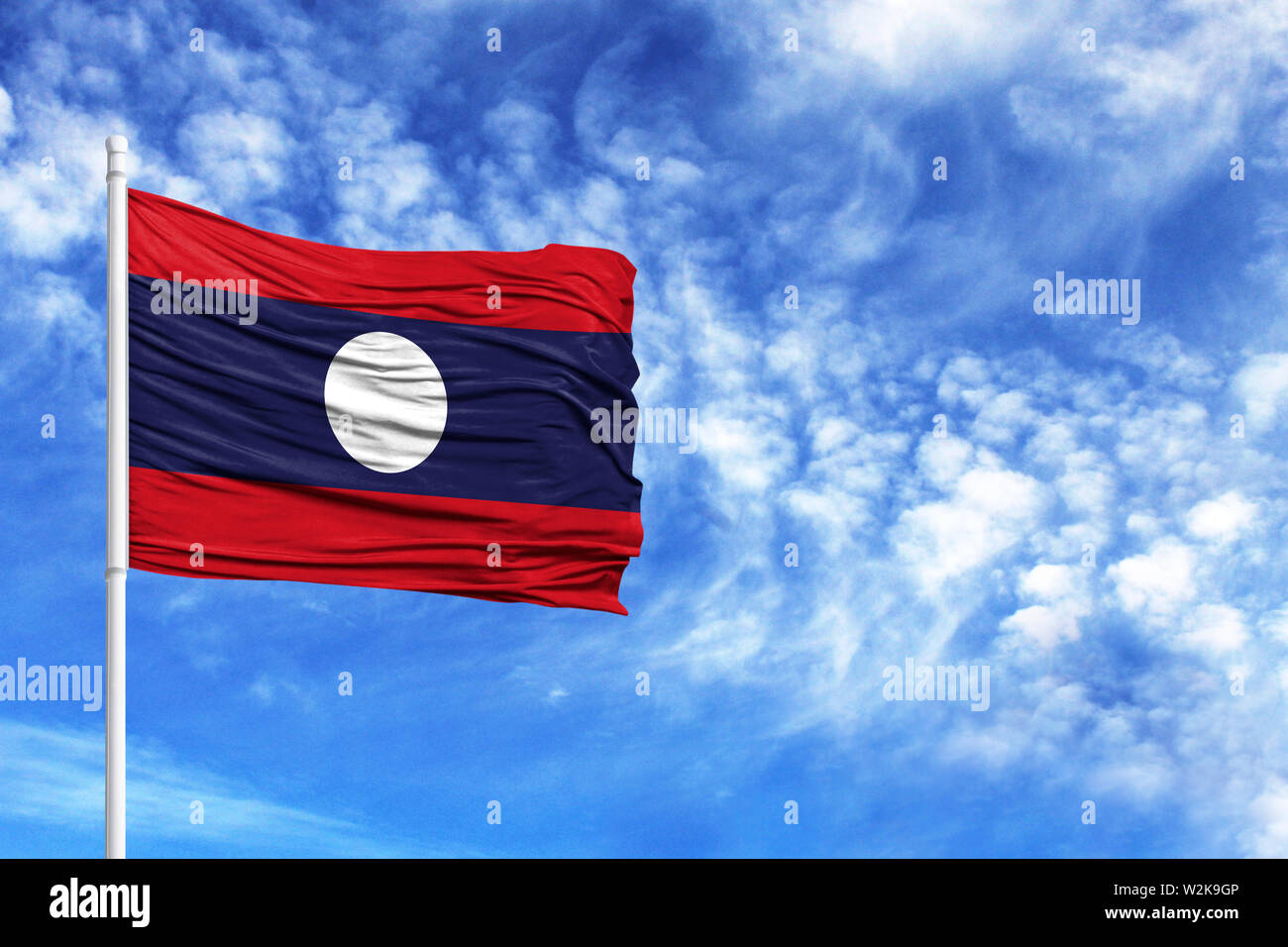 National flag of Laos on a flagpole in front of blue sky Stock Photo ...
