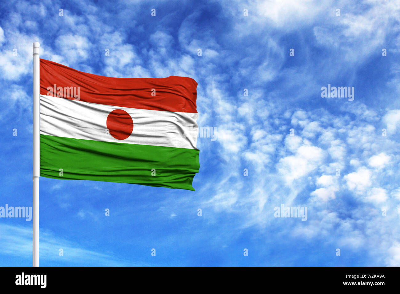 National flag of Niger on a flagpole in front of blue sky Stock Photo ...