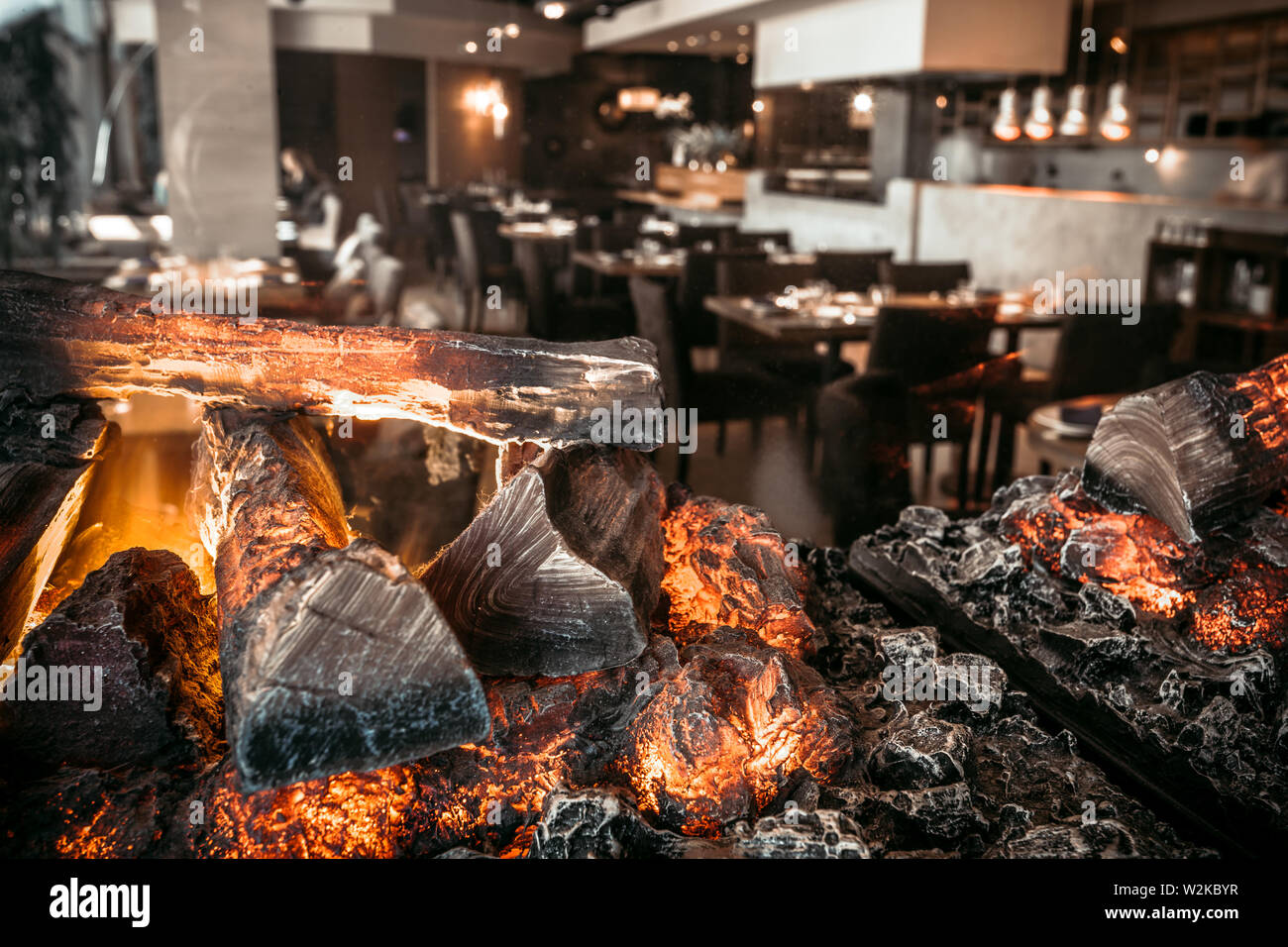 Interior of modern restaurant with fireplace close-up Stock Photo - Alamy