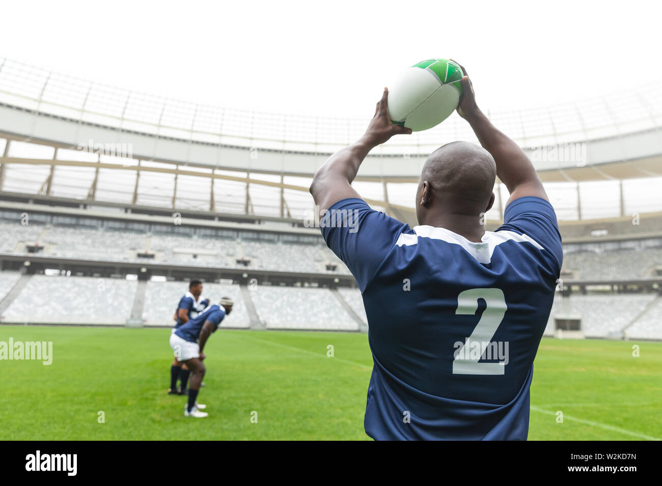 African American male rugby player throwing rugby ball in stadium Stock ...