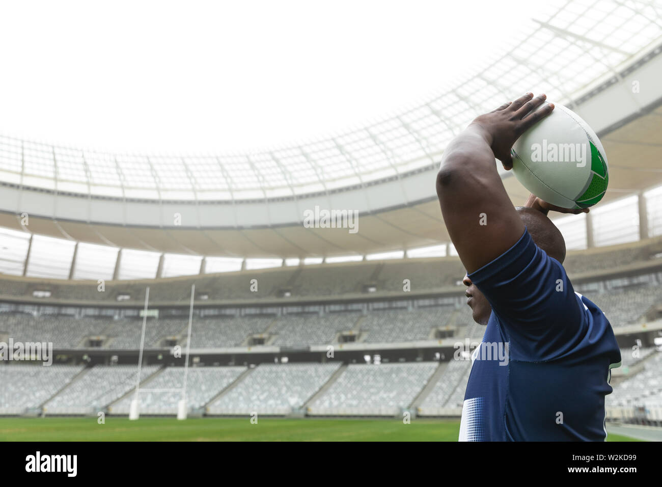 African American male rugby player throwing rugby ball in stadium Stock ...