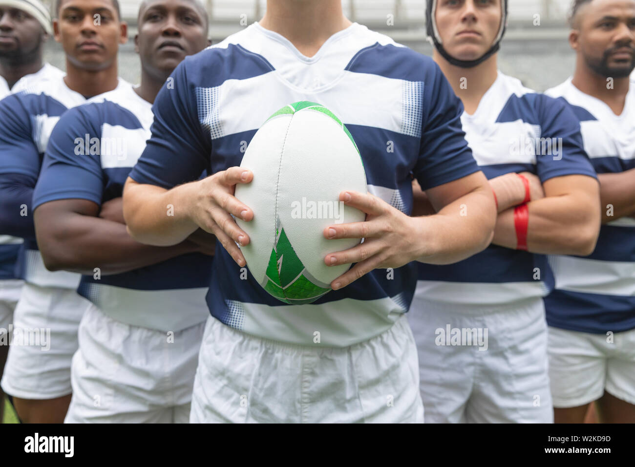 Group of diverse male rugby players standing together with rugby ball ...