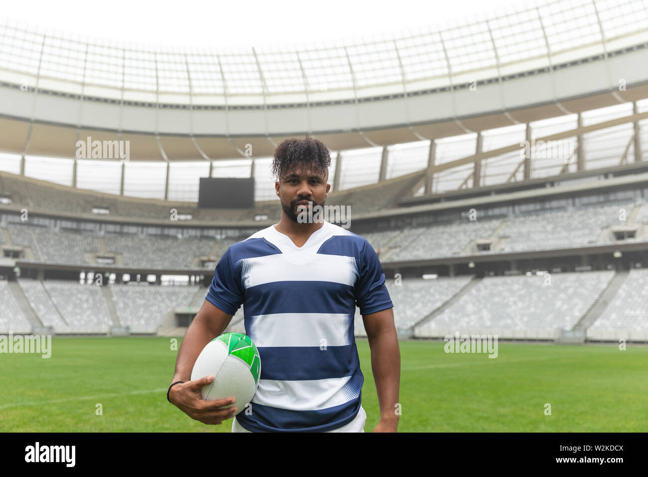 African American rugby player standing with rugby ball in stadium Stock ...