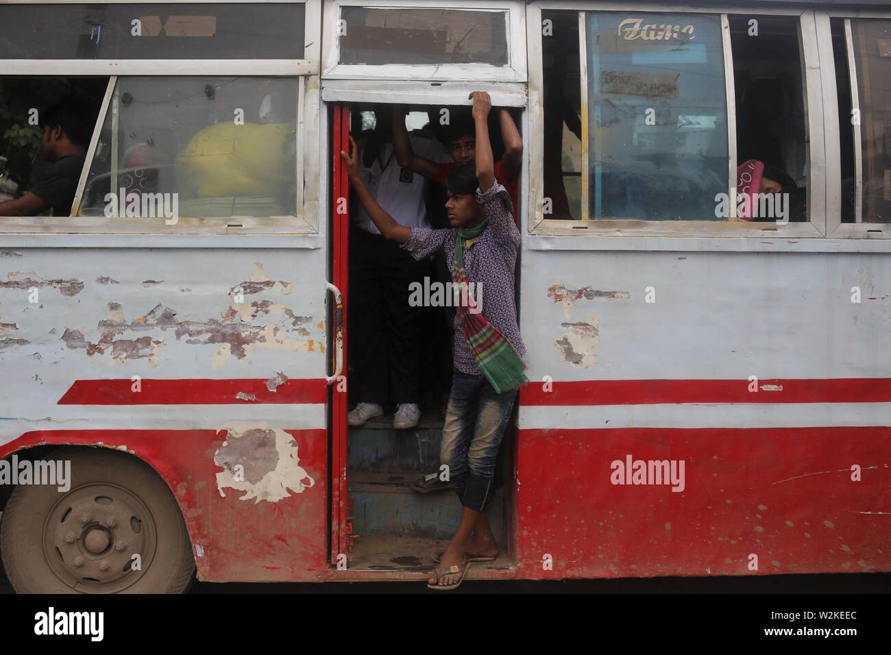 Dhaka, Bangladesh. 10th July, 2019. A boy standing at the door of a bus ...
