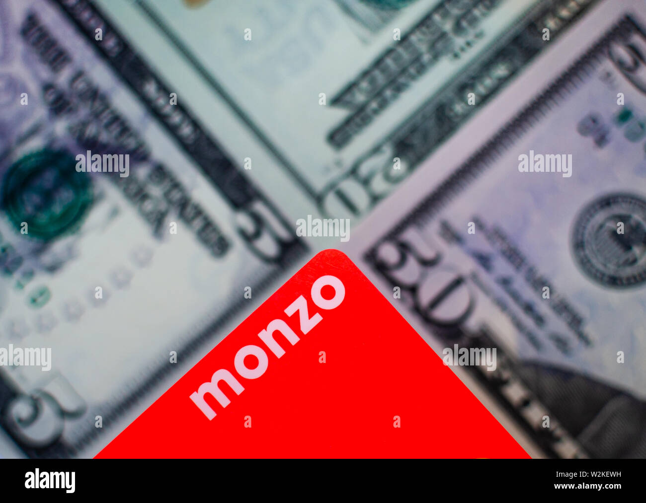Monzo Bank cards on a blurred background of dollar bills different ...