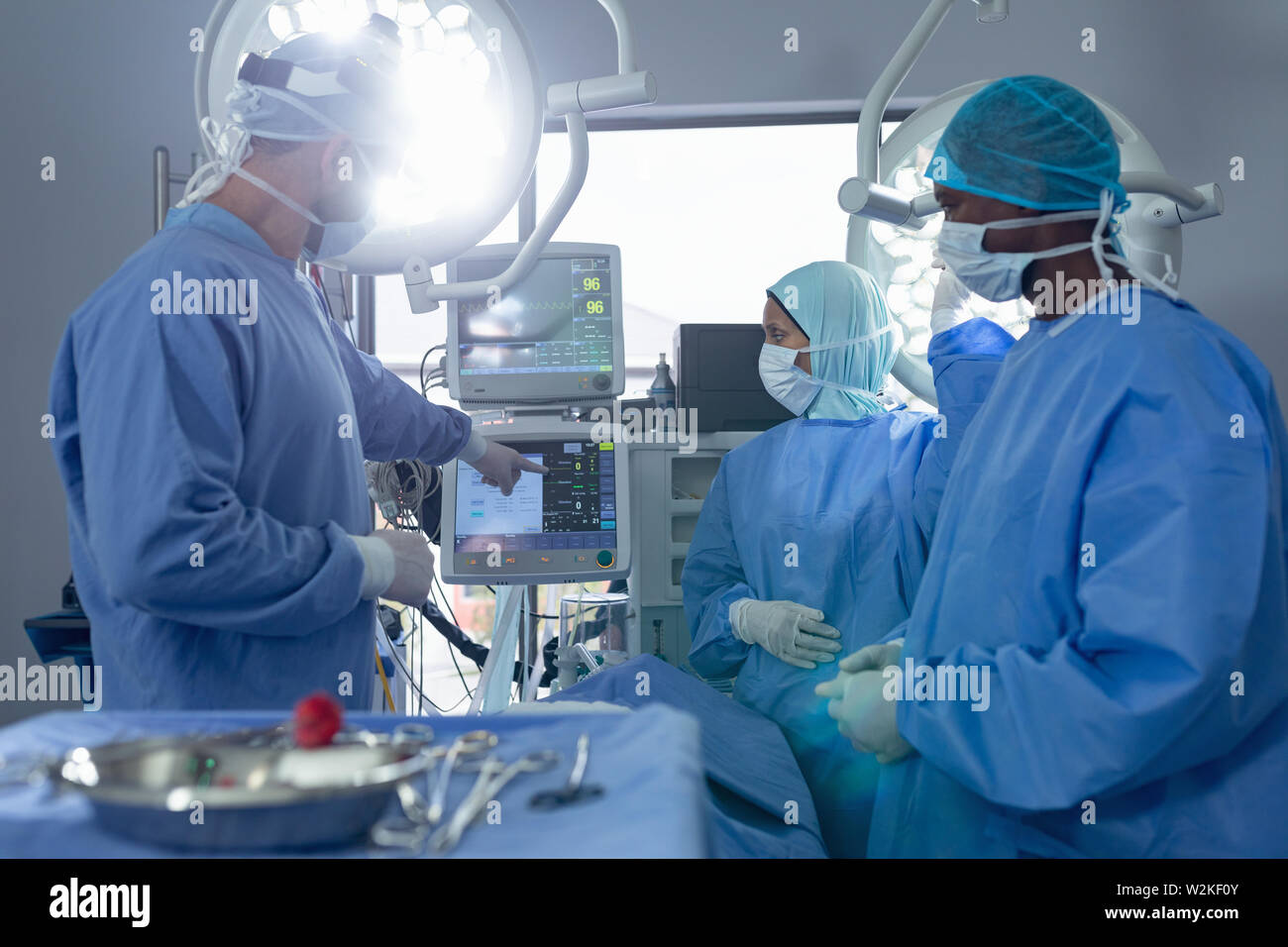 Surgeons discussing over medical monitor in operation theater at ...
