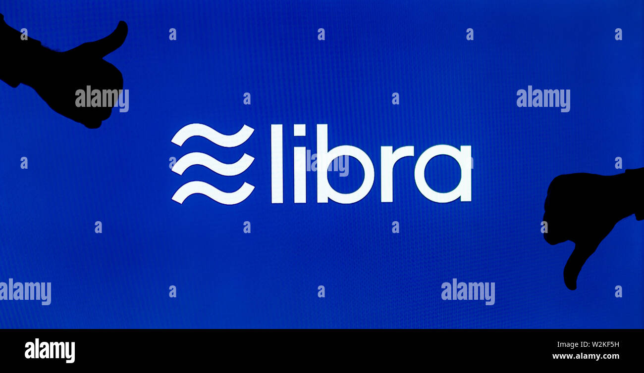 Facebook Libra cryptocurrency logo on the screen and the silhouette of ...